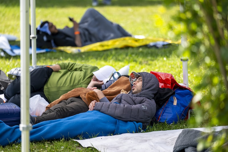 Weer maaltijden en meloenen voor wachtende asielzoekers op grasveld bij ...